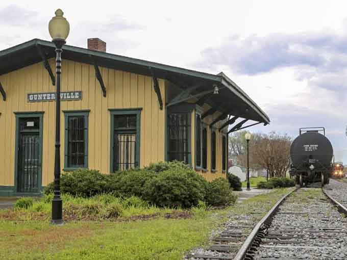 That vintage tank car parked trackside adds authentic railroad atmosphere to this beautifully maintained lakeside depot.