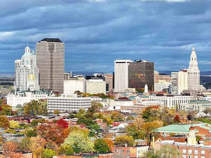 Dramatic clouds hover over the skyline as autumn colors paint the foreground in brilliant hues.