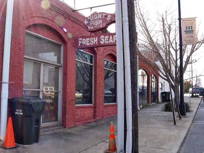That old fish market sign arches over the sidewalk, whispering tales of fresh catches and bustling commerce from decades past.