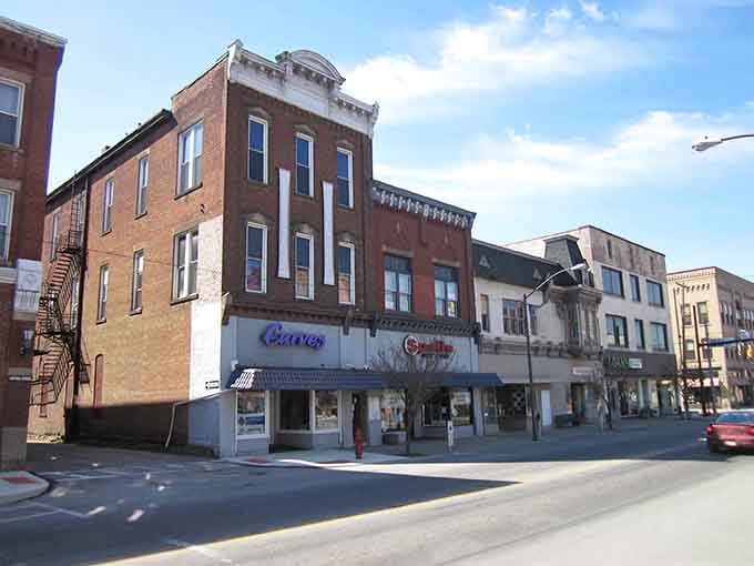 Sunshine bouncing off brick storefronts in Punxsutawney, where Carvel and Sprint share sidewalk space with small-town history.