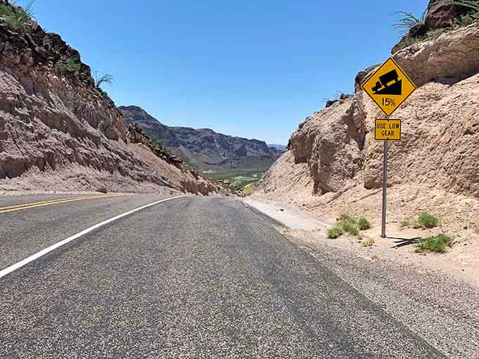 That steep descent warning sign tells you you're in for a thrilling ride through this dramatic mountain pass carved by time.