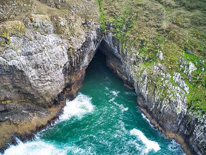 The rocky entrance beckons adventurers down into darkness, where ancient lava once flowed like a river of fire.