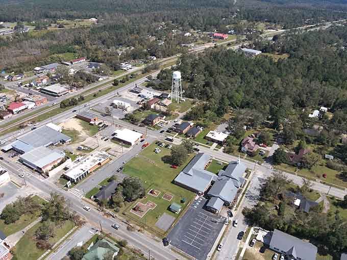 From the sky, this small town spreads beneath green forests, showing how affordable communities nestle peacefully in nature's embrace.
