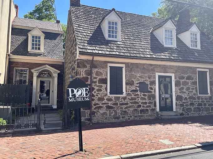 Stone cottage entrance welcomes visitors into intimate museum spaces filled with handwritten manuscripts and memorabilia.