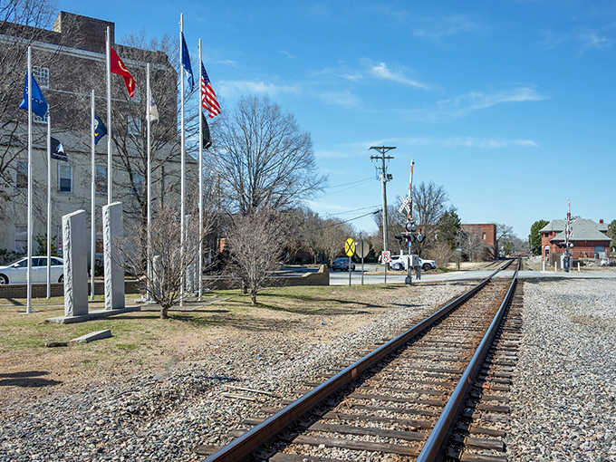 Railroad tracks cut through town alongside proud flags, reminding everyone that history still runs through these streets.