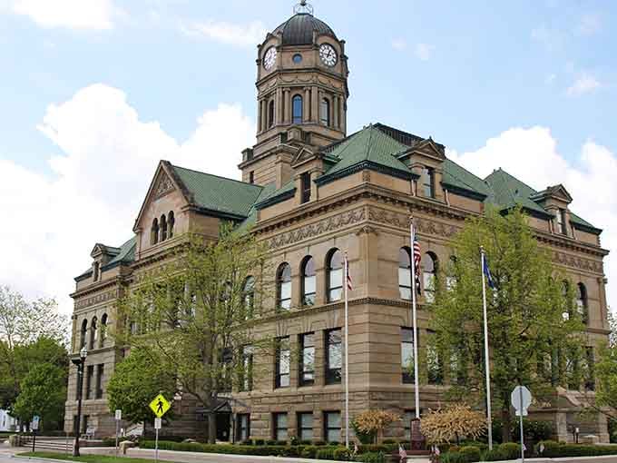 This stately courthouse sits surrounded by spring greenery, its Romanesque design commanding attention like a Victorian-era celebrity.