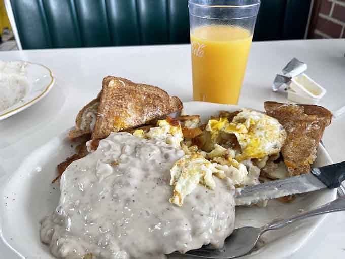 Orange juice, wheat toast, and a biscuit buried under enough sausage gravy to fuel a construction crew.