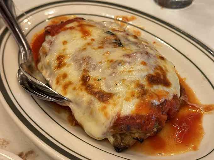 Eggplant parmigiana with layers of cheese so generous they'd make your cardiologist schedule an intervention immediately.