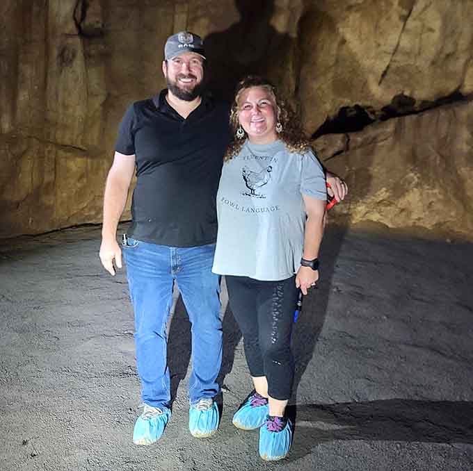Visitors don protective booties and strike a pose, ready to explore while keeping the delicate cave environment pristine for future generations.