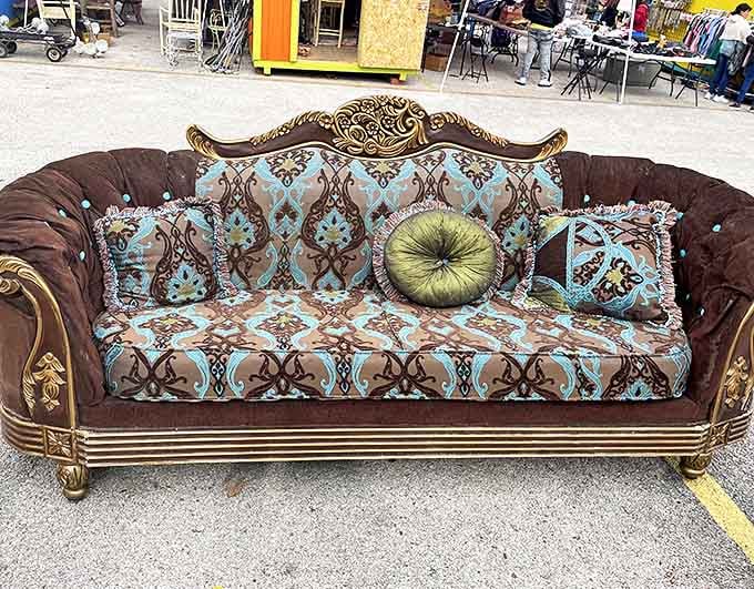 This ornate sofa is giving serious "your grandmother's fancy living room" vibes, and it's absolutely magnificent in its decorative glory.