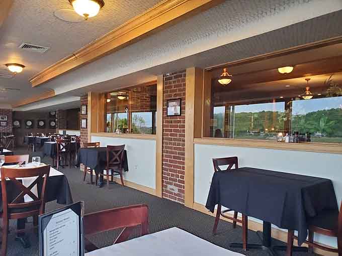 Floor-to-ceiling windows frame the river view while crisp linens wait patiently, ready to catch whatever deliciousness comes their way.