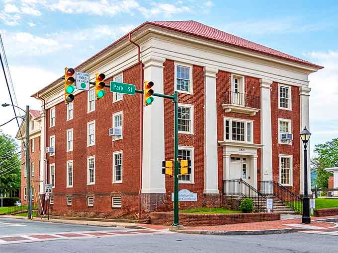 Historic red brick walls and grand white columns welcome you to this charming landmark standing tall under a bright sky.