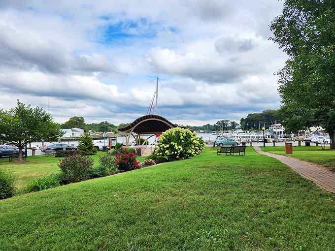 Manicured lawns slope gently toward the marina where sailboats bob peacefully beneath clouds that refuse to hurry anywhere.