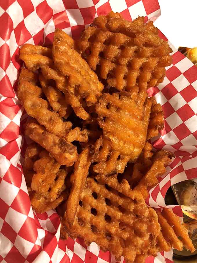 Sweet potato fries in a red checkered basket, proving that even the sides deserve their moment of glory.