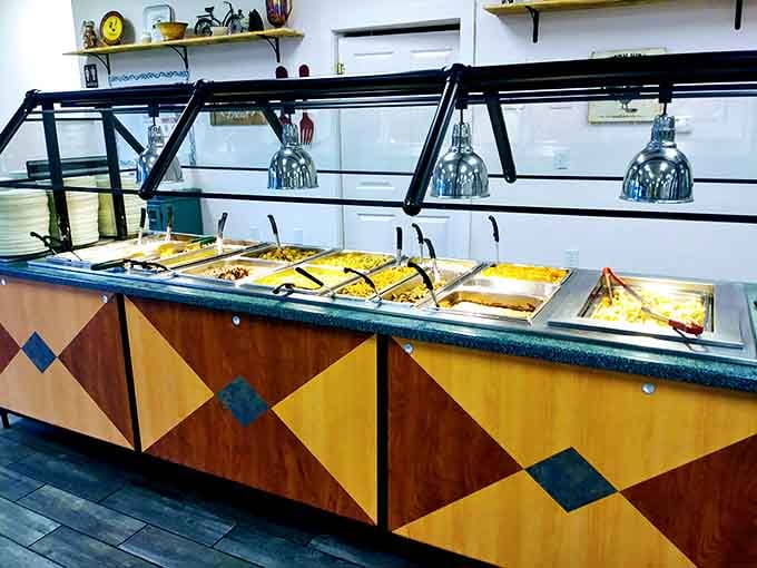 The buffet station stretches out like a delicious promise, heat lamps keeping everything warm and ready for action.