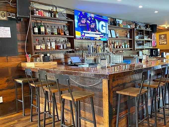 The bar area combines rustic charm with serious beverage options, making it everyone's favorite waiting spot.
