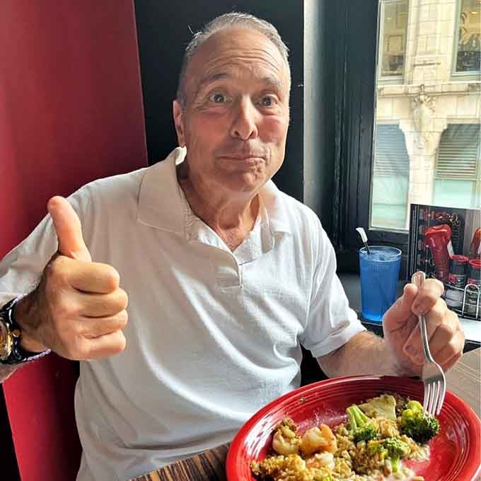 Pure satisfaction captured in a thumbs-up moment with a perfectly customized bowl of grilled goodness.