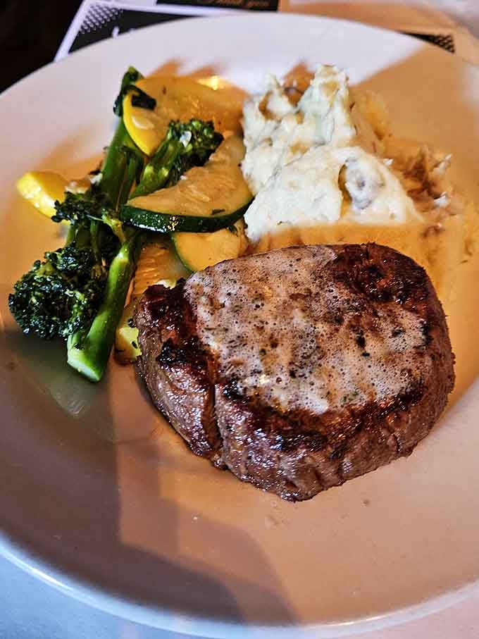 The filet mignon sits pretty with vegetables and mash, tender enough to cut with harsh language alone.