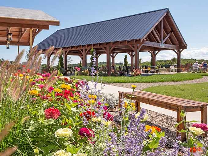 Vibrant blooms frame the pavilion where vineyard views stretch endlessly, making every sip taste even better than the last.