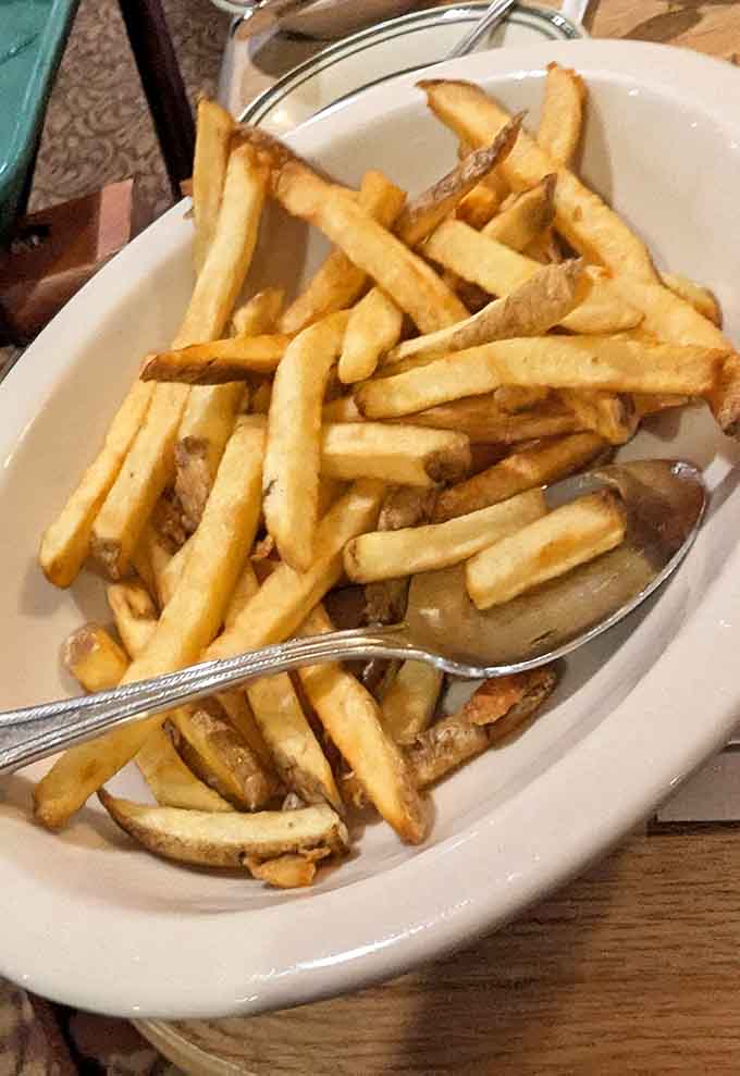 Hand-cut fries piled high in a bowl, because apparently someone decided plates were for quitters and the weak-willed.