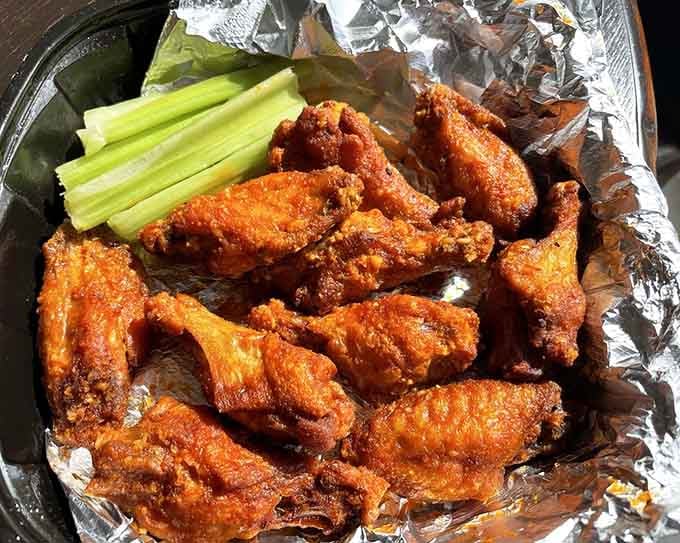 Wings glazed in spicy garlic perfection, served with celery because someone remembered vegetables exist after all.