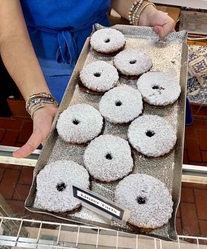 Heart-shaped Linzer tarts filled with jam prove that love and powdered sugar solve most problems beautifully.