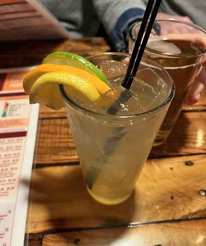 Fresh citrus garnish and a cold beverage that looks like liquid sunshine in a glass, perfect for washing down pizza.