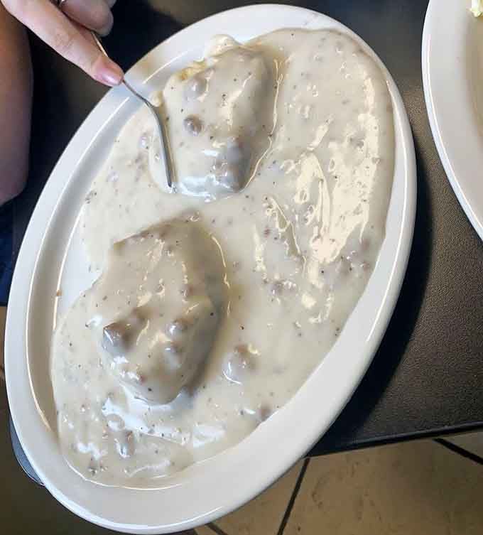 Biscuits swimming in sausage gravy, the kind of dish that makes you understand why people wake up early.