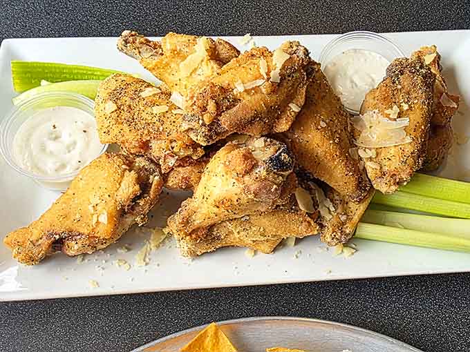 Buffalo wings arrive perfectly crispy with celery stalks standing guard, ready to cool down the heat when things get spicy.