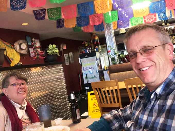 Happy diners enjoying their meal beneath festive decorations, proof that Jenny's has been feeding smiles for years.
