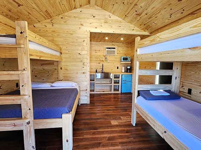 Cabin interiors with bunk beds and wood paneling, rustic charm meets actual comfort for happy campers.