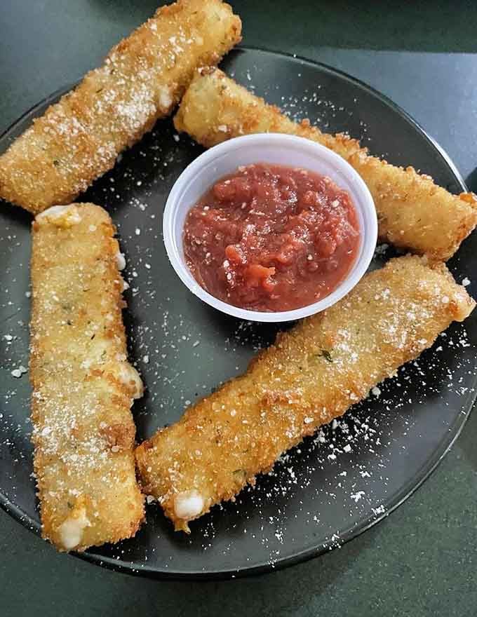 Golden mozzarella sticks that stretch like they're auditioning for a cheese commercial, marinara standing by for support.