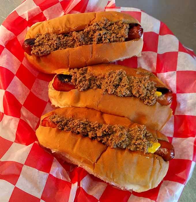 Three hot dogs loaded with what appears to be heaven, proving they're not just burger specialists.