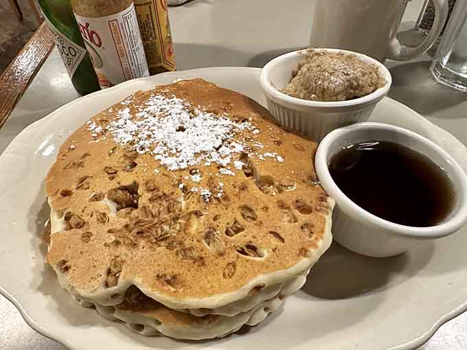 Fluffy pancakes studded with granola and dusted with powdered sugar, because sometimes healthy ingredients deserve butter too.