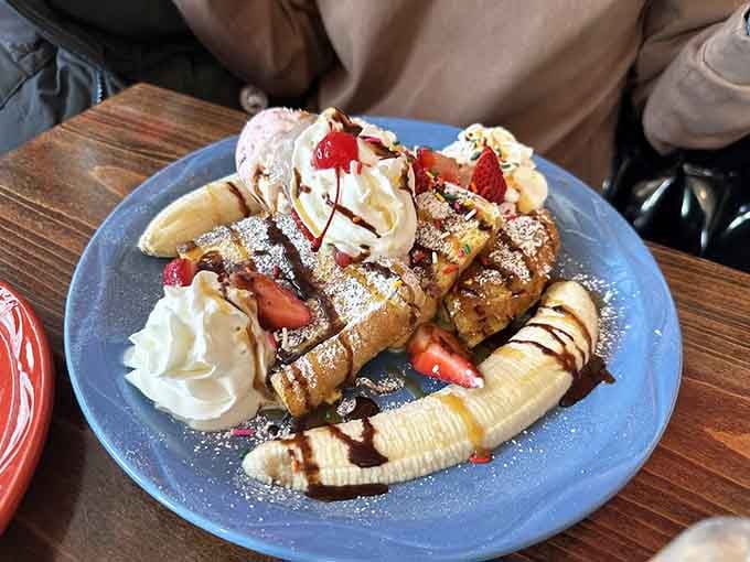 French toast loaded with strawberries, bananas, and whipped cream proves dessert for breakfast is absolutely acceptable here always.