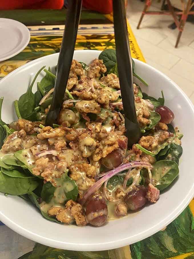 Fresh spinach salad topped with walnuts and all the good stuff that makes you feel virtuous before pizza.