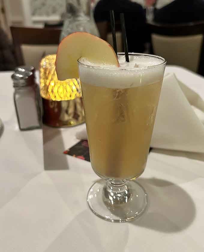 A whiskey sour garnished with apple, looking refreshing enough to make you forget it's basically dessert in a glass.