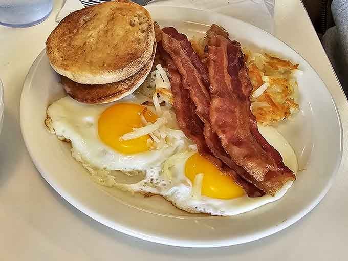 Bacon cooked to crispy perfection, sunny eggs, and an English muffin &ndash; the holy trinity of morning satisfaction awaits.