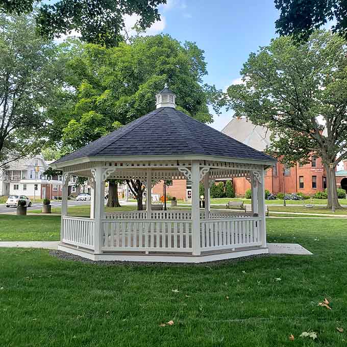 The town gazebo stands ready for concerts, proposals, or just sitting and remembering when life moved at a gentler pace.