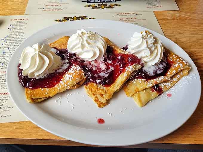 Berry crepes dusted with powdered sugar, proving breakfast can be as indulgent as dessert here.