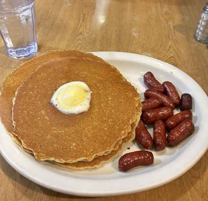 Fluffy pancakes with a butter pat melting slowly: breakfast poetry served on a diner plate.