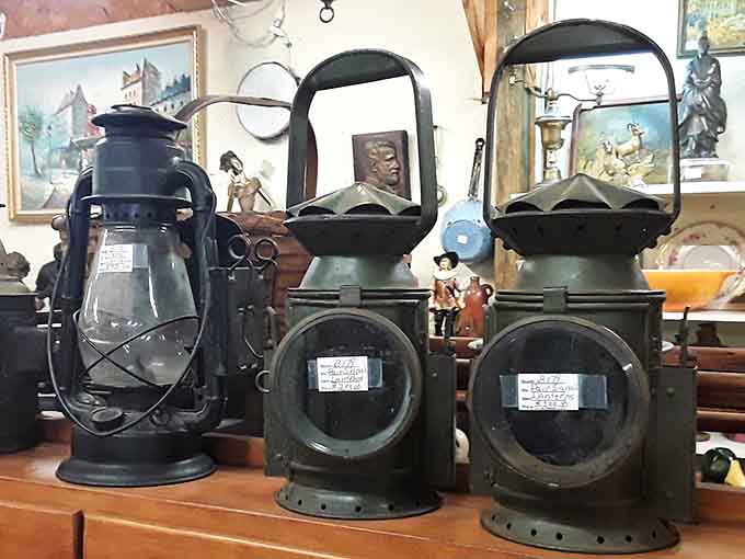 These railroad lanterns once guided trains through darkness, now they just guide you toward your credit card.