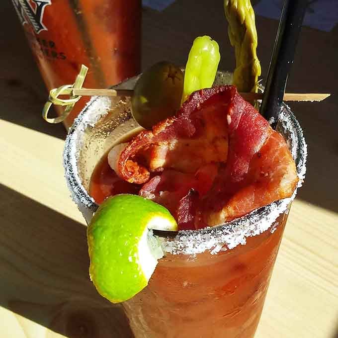 That Bloody Mary comes loaded with bacon, pickles, and enough garnishes to qualify as an appetizer itself.