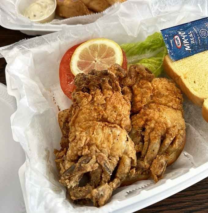Crispy soft shell crab nestled in a basket with fresh tomato and lemon, proving sometimes simple preparations are the most sublime.