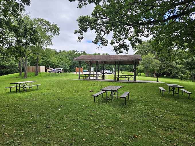 Classic picnic shelter stands ready for family reunions, where potato salad debates and horseshoe tournaments reign supreme annually.