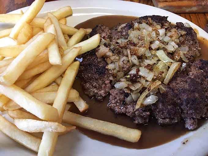 Hamburger steak smothered in onions and gravy, proving comfort food is alive and thriving here.