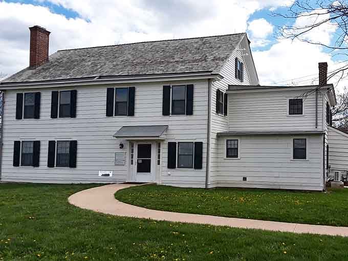 Classic colonial architecture meets modern lawn care, because even haunted houses need to keep up with the neighbors.