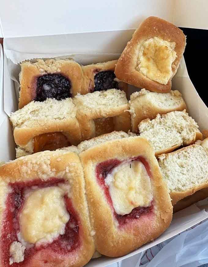 A box of assorted kolaches represents every good decision you've made today, all conveniently packaged for immediate consumption.