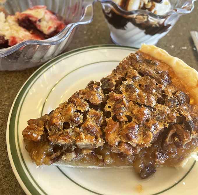 Pecan pie with that gorgeous caramelized top layer whispers sweet promises of Southern comfort in every gooey bite.