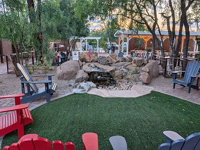 Stone water feature surrounded by Adirondack chairs creates an outdoor oasis that rivals any backyard dream setup.